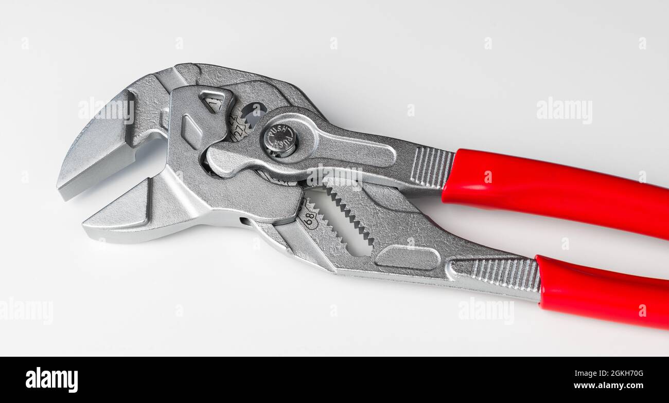 Tongue-and-groove slip-joint pliers detail with movable jaw on a white ...