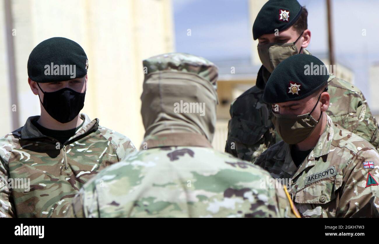 British Army soldiers ask questions to an observer, coach and trainer ...