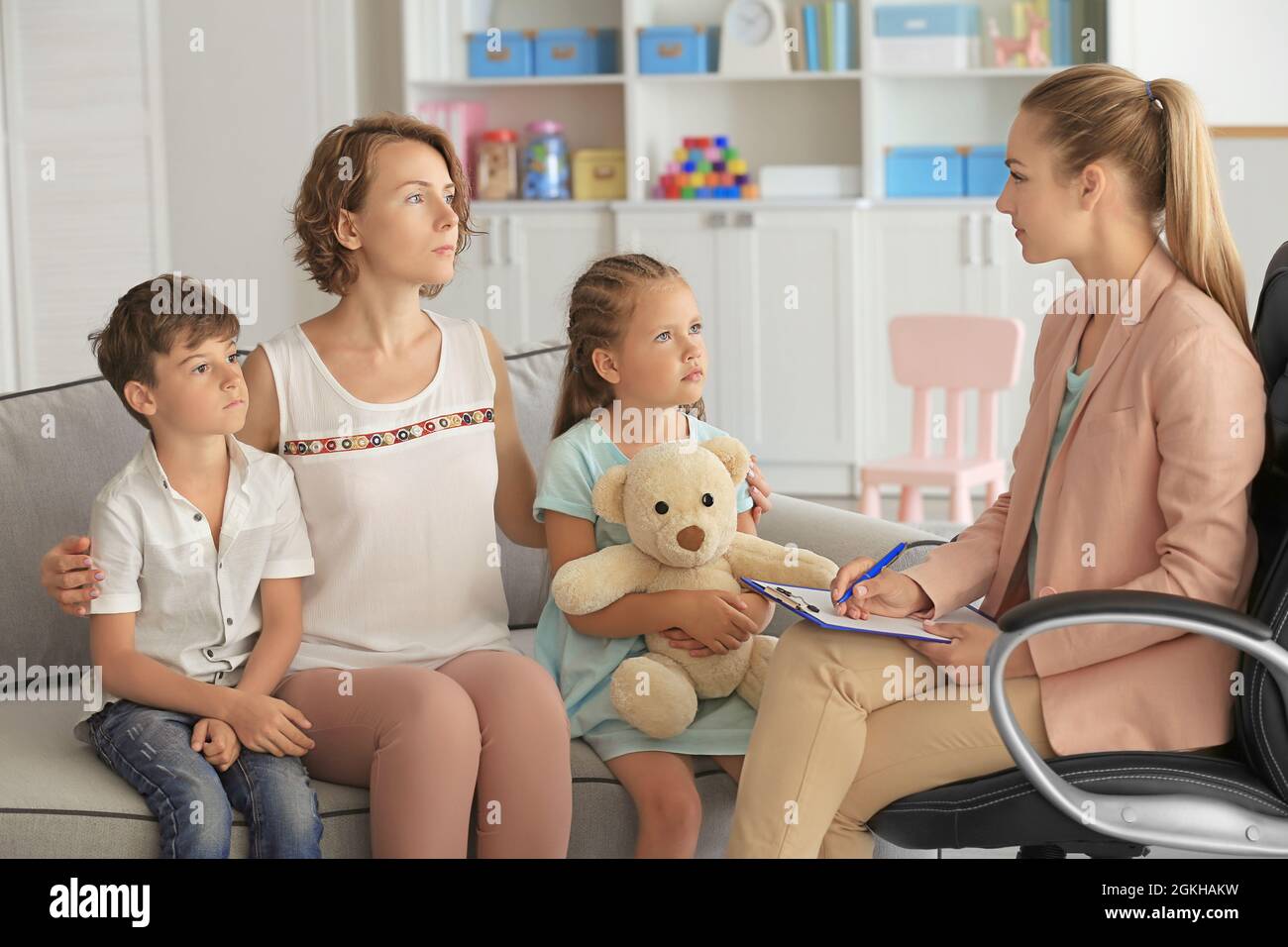Young child psychologist working with family in office Stock Photo - Alamy