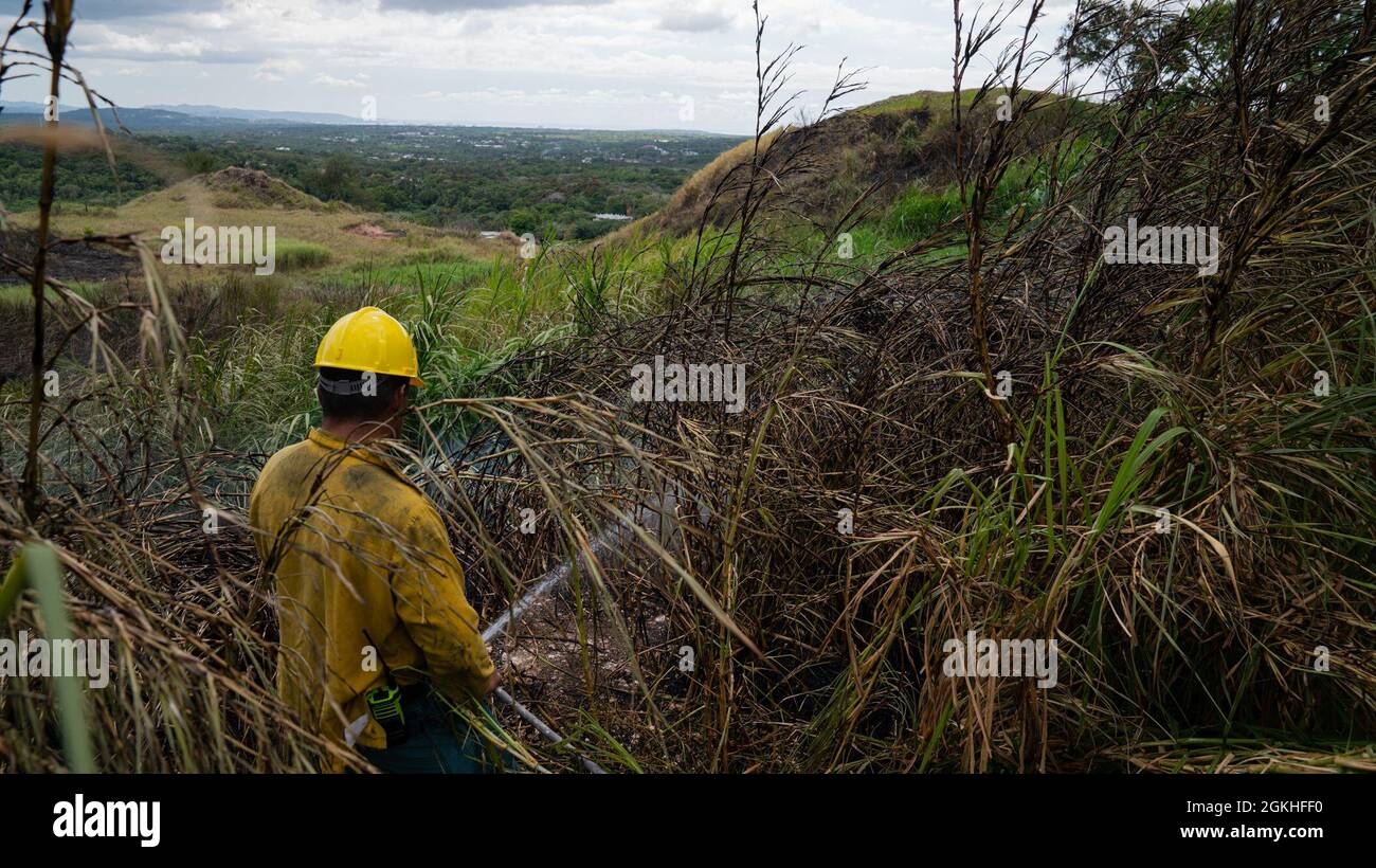 A Guam Fire Department firefighter extinguishes a small fire after a ...