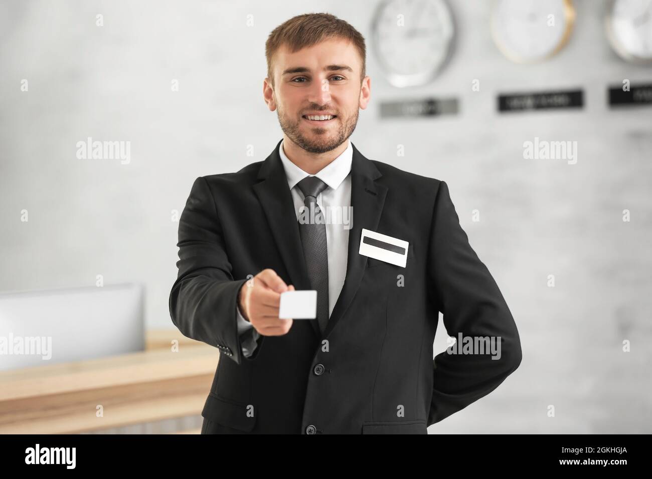 Male receptionist with card in hotel Stock Photo - Alamy