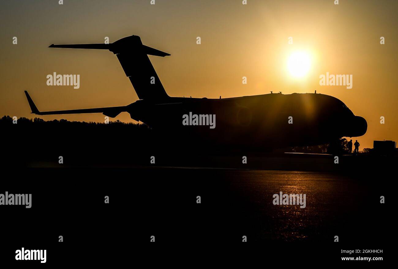 The sun rises over a C-17 Globemaster III aircraft on the flight line ...
