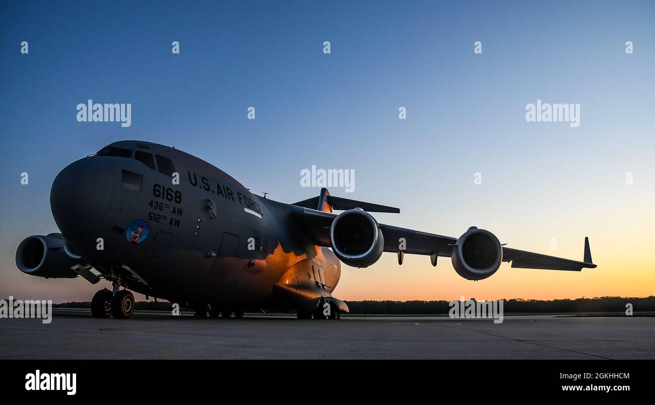 The sun rises over a C-17 Globemaster III aircraft on the flight line ...