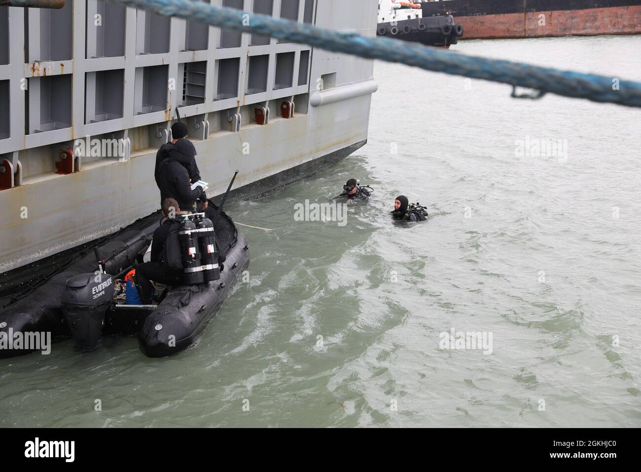 U.S. Army divers from the 86th Engineer Dive Detachment surface from a ...