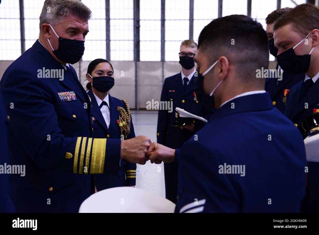 Coast Guard Commandant Adm. Karl L. Schultz fist bumps a crewmember ...