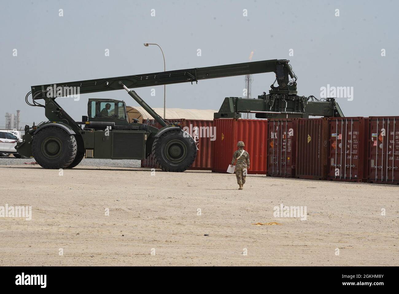 A rough terrain container handler operator arranges containers off ...