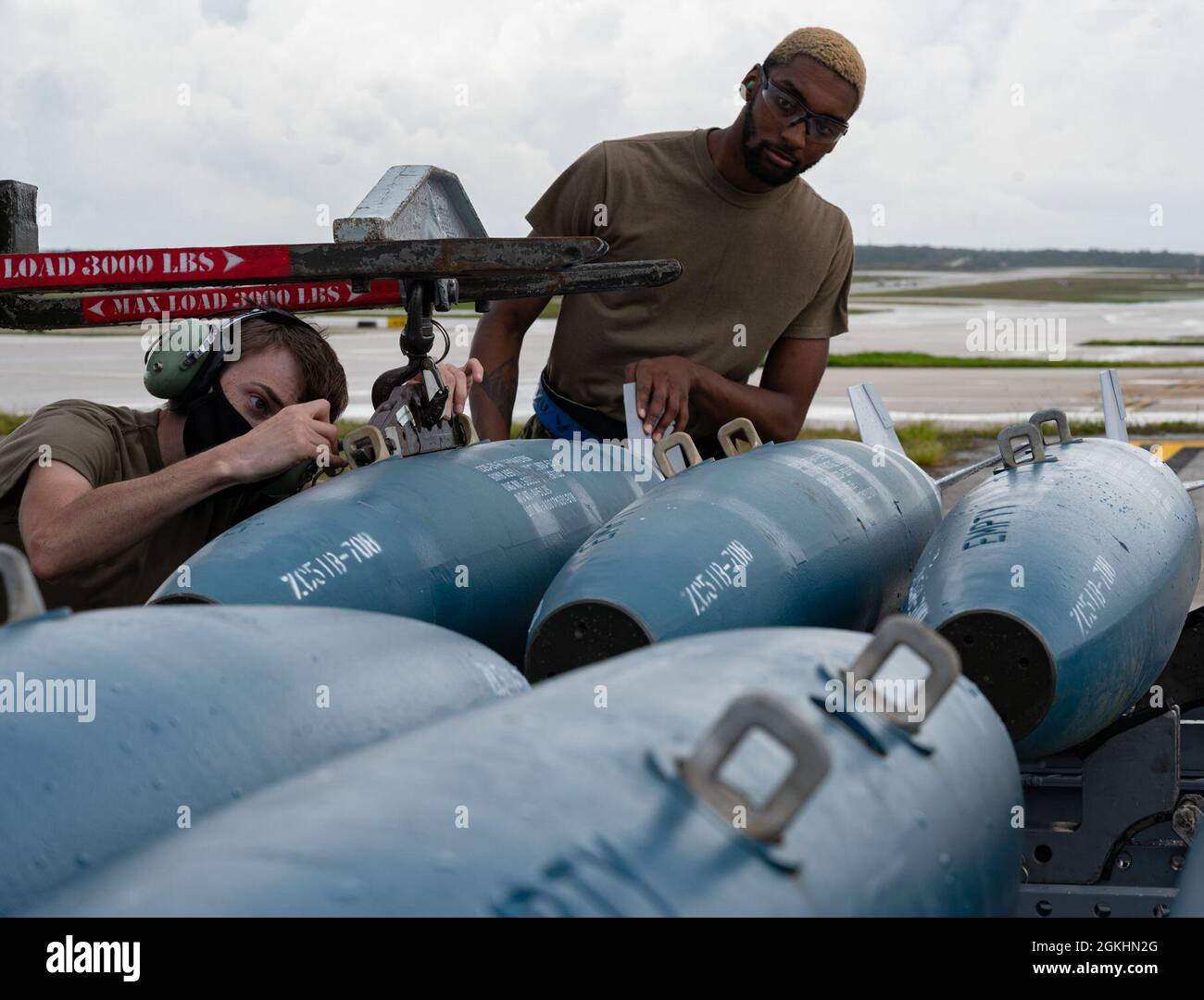 U.S. Air Force Airmen connect to a BDU-50 chronicle bomb to transport ...