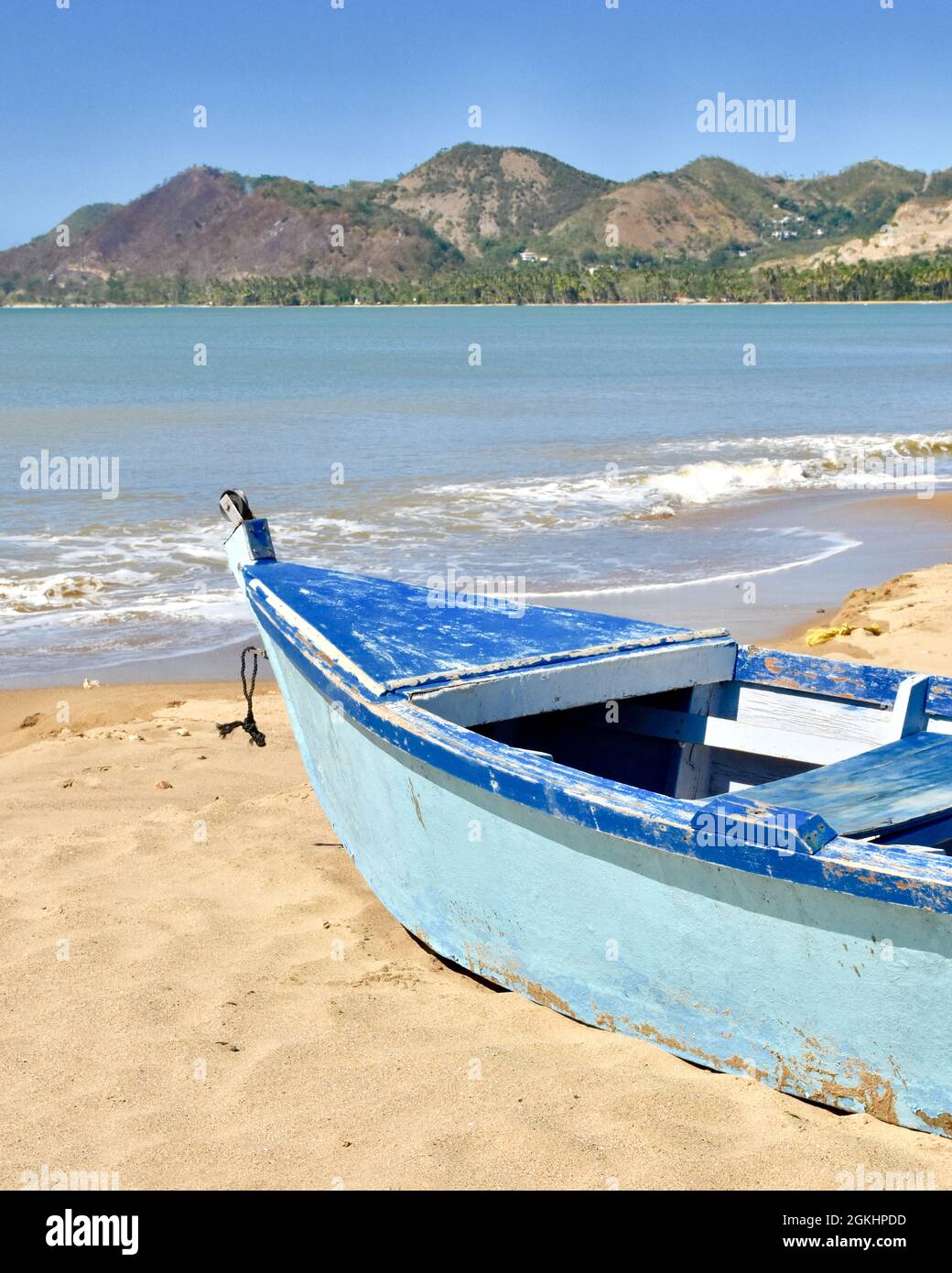 Traditional Caribbean fishing boat on a sand beach with hills in the ...