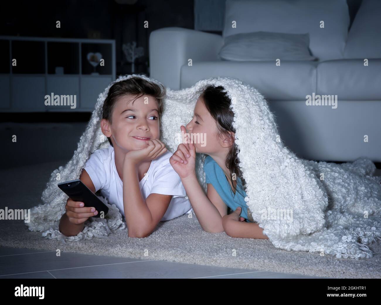 Cute children watching TV on floor at night Stock Photo - Alamy