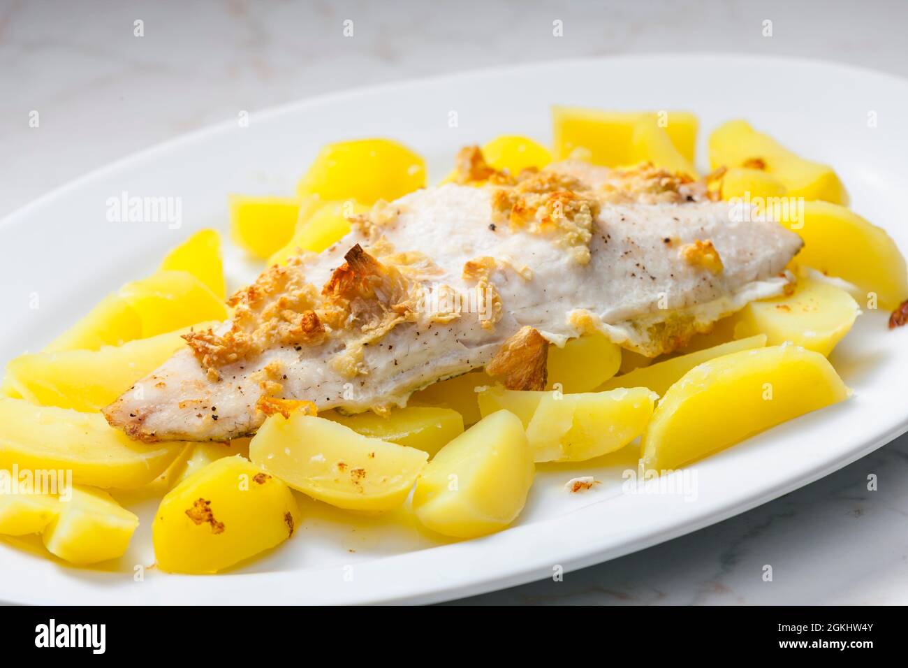zander on garlic served with cooked potatoes Stock Photo - Alamy