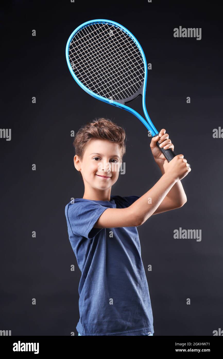 Cute little boy with tennis racket on dark background Stock Photo - Alamy