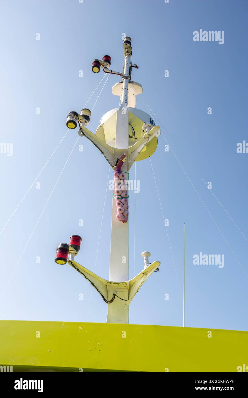 Recreational boat mast with signal lights, radar and a string of garlic ...