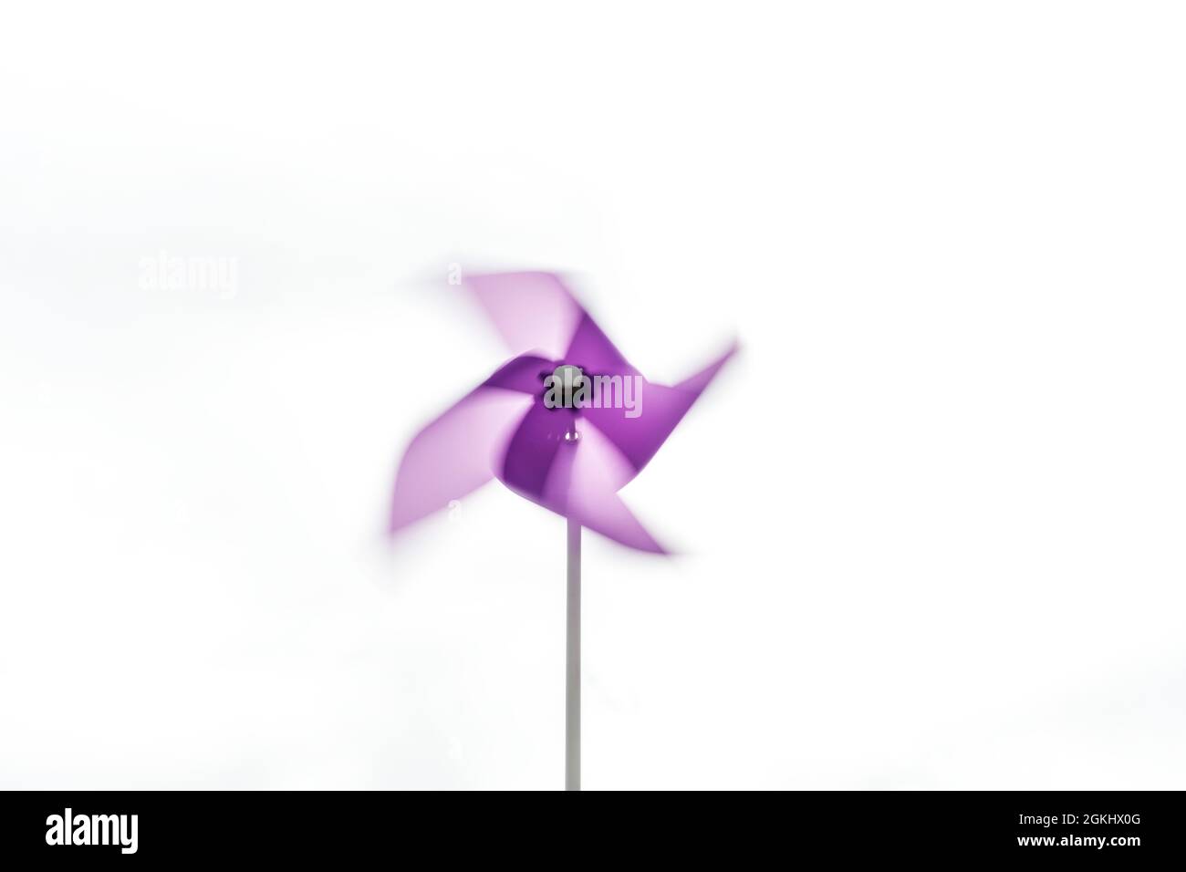 Purple pinwheel turning its blades under the effect of a light breeze ...