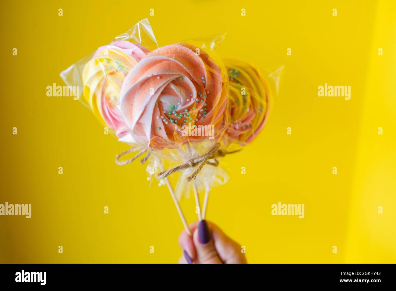 A woman holding a colorful candy in hand Stock Photo - Alamy