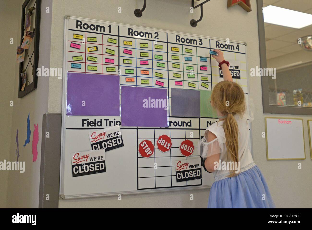A child moves her name tag on a white board at the School Age Program building on Goodfellow Air ...