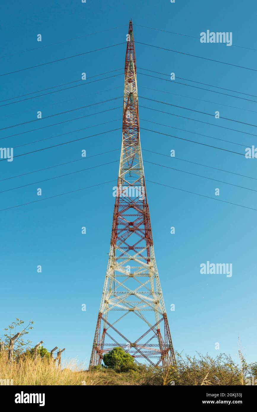 High tension steel tower painted in white and red loaded with electric ...
