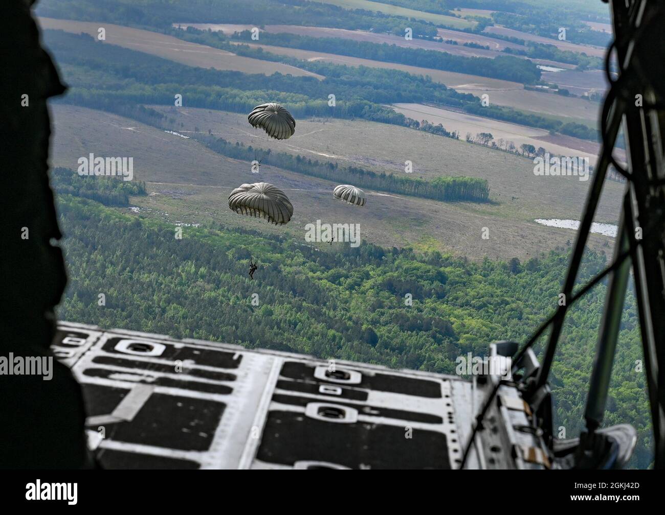 U.S. Airmen and Soldiers jump off the ramp of a C-130 Hercules aircraft ...