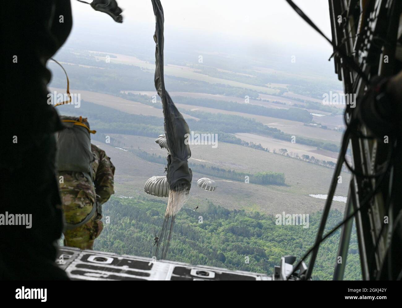 U.S. Airmen and Soldiers jump off the ramp of a C-130 Hercules aircraft ...