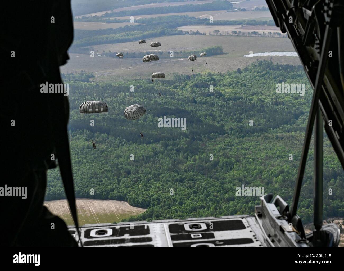 U.S. Airmen and Soldiers jump off the ramp of a C-130 Hercules aircraft ...