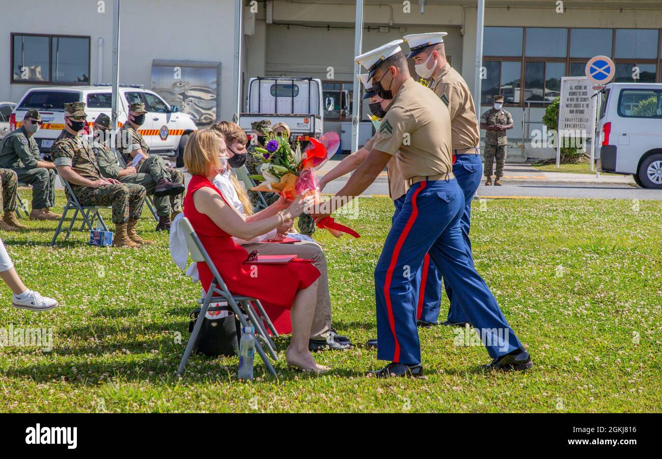 U.S. Marines with 1st Marine Aircraft wing, give flowers to the family ...