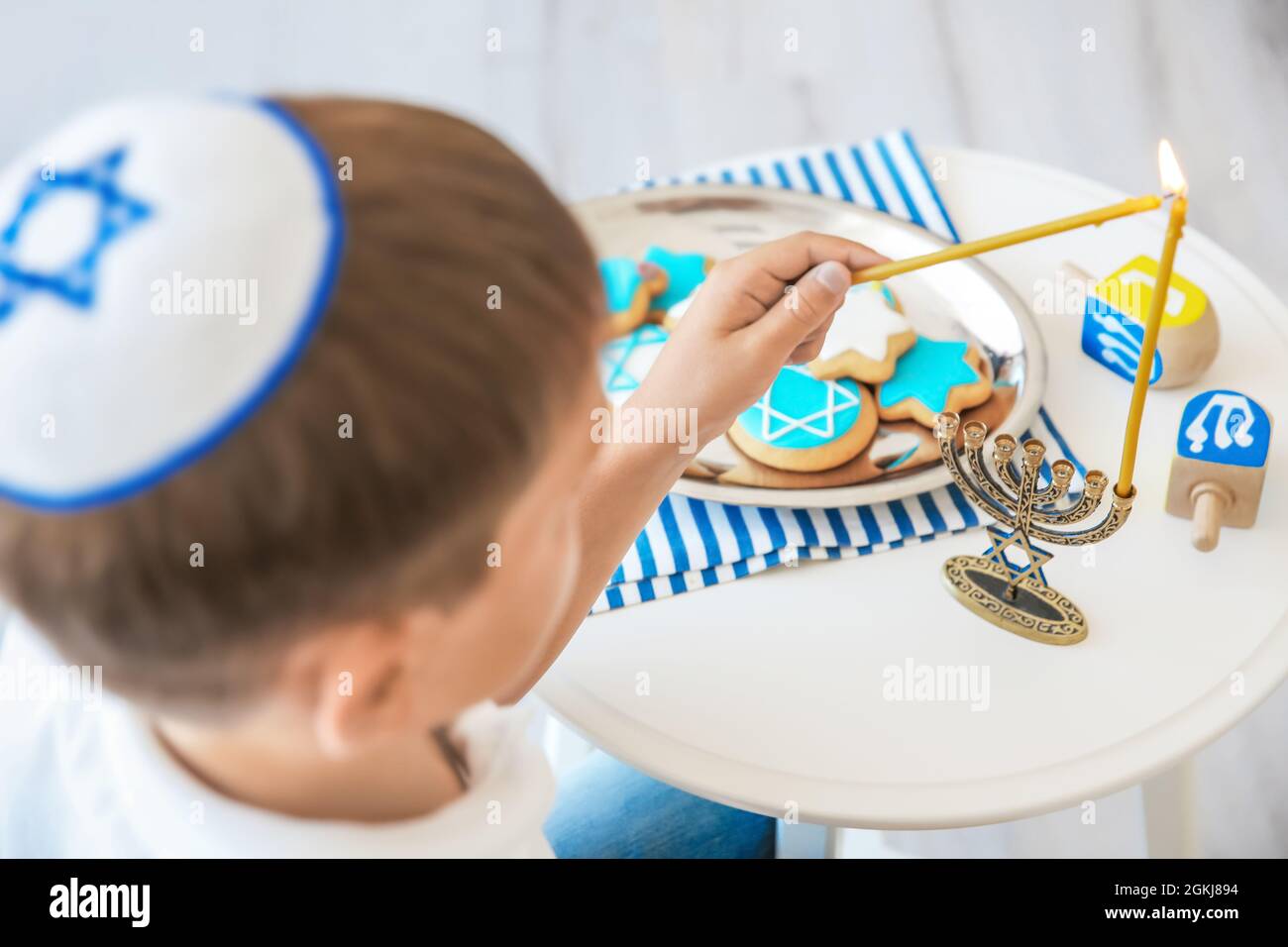 Jewish boy lightning menorah at home Stock Photo - Alamy