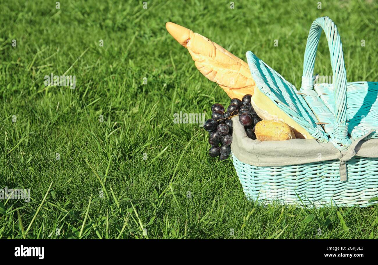 Wicker basket with picnic stuff on green grass Stock Photo - Alamy