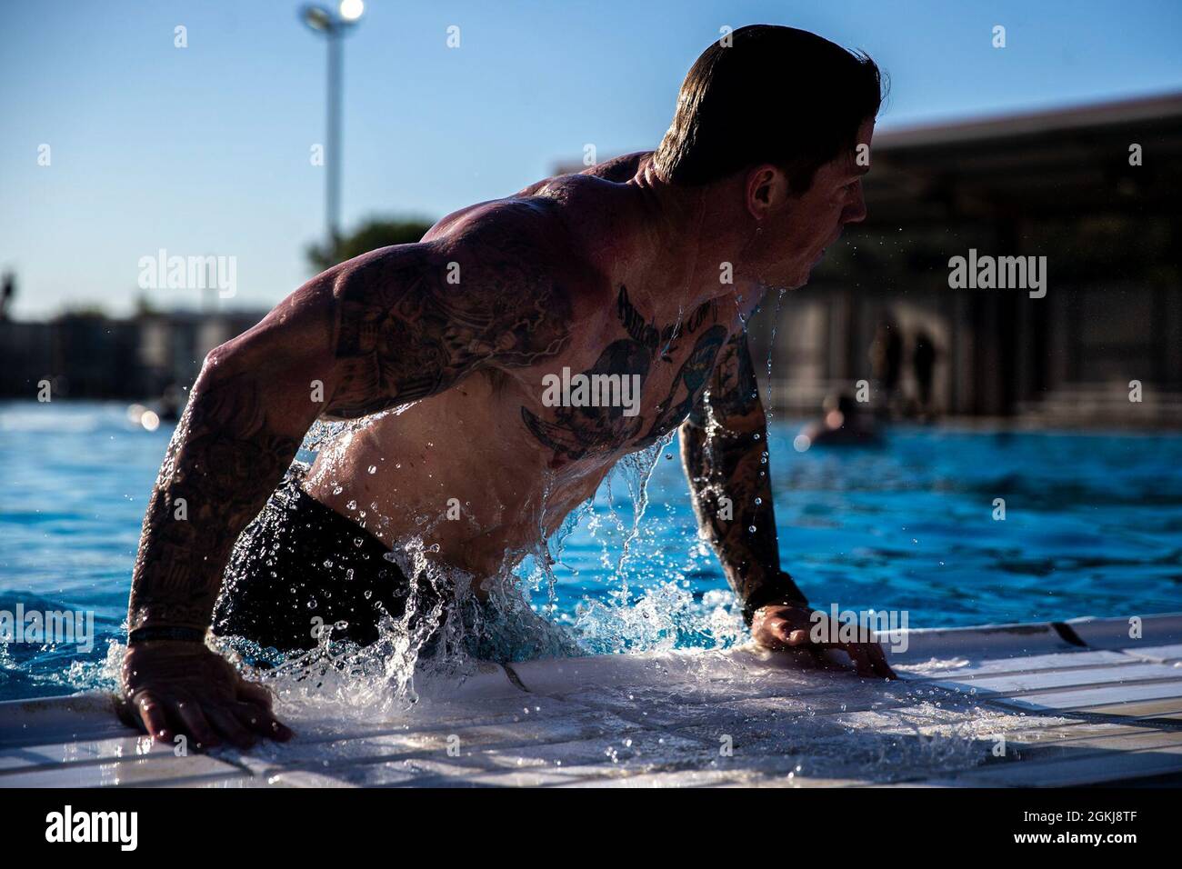 A U.S. Navy sailor jumps out of the Recon Training Company pool during ...
