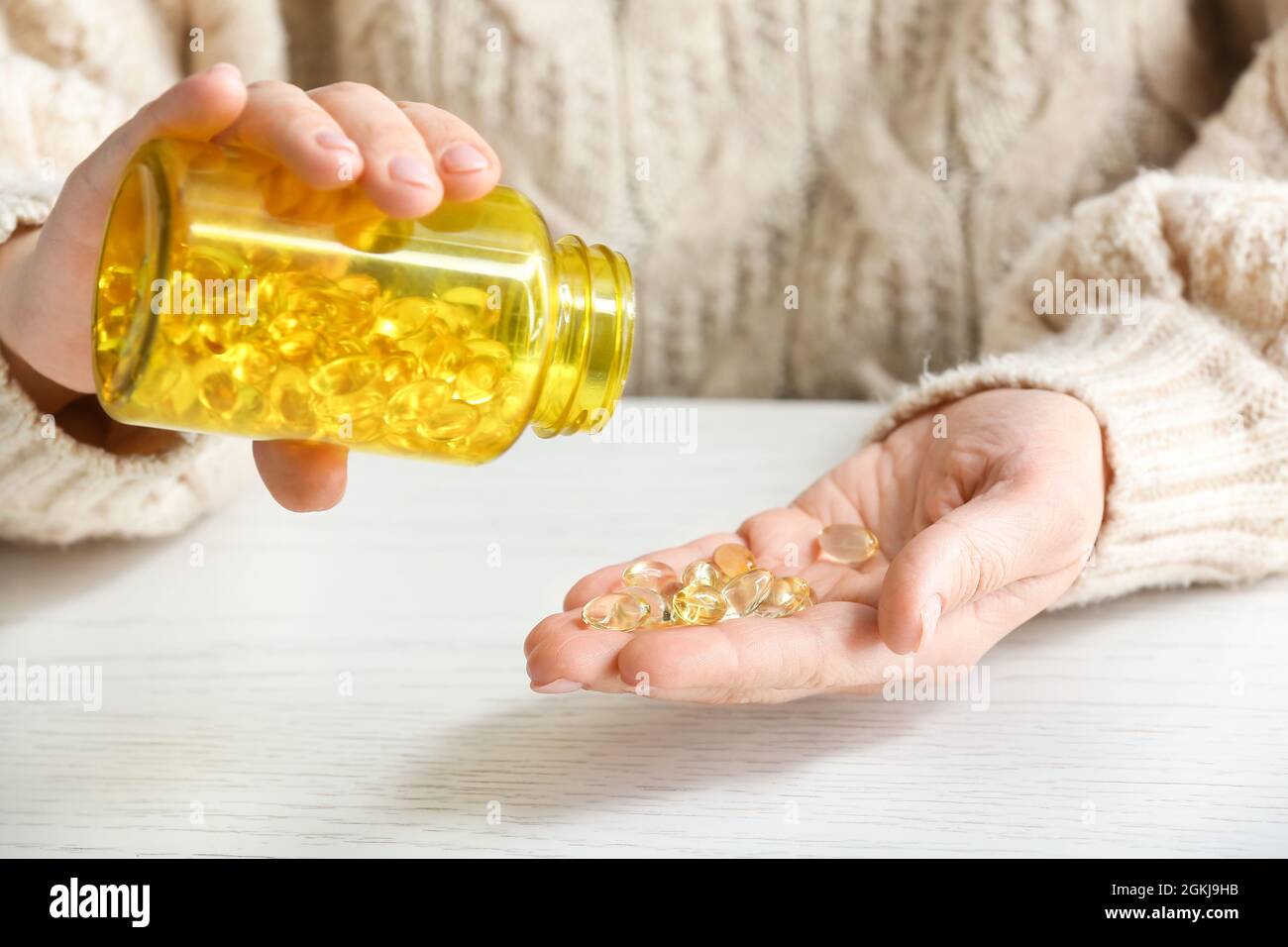 Woman fish oil capsules wooden hi-res stock photography and images - Alamy