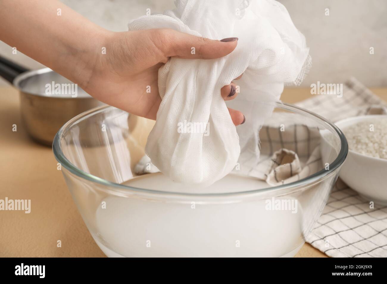 Woman preparing tasty rice milk on kitchen table, closeup Stock Photo ...