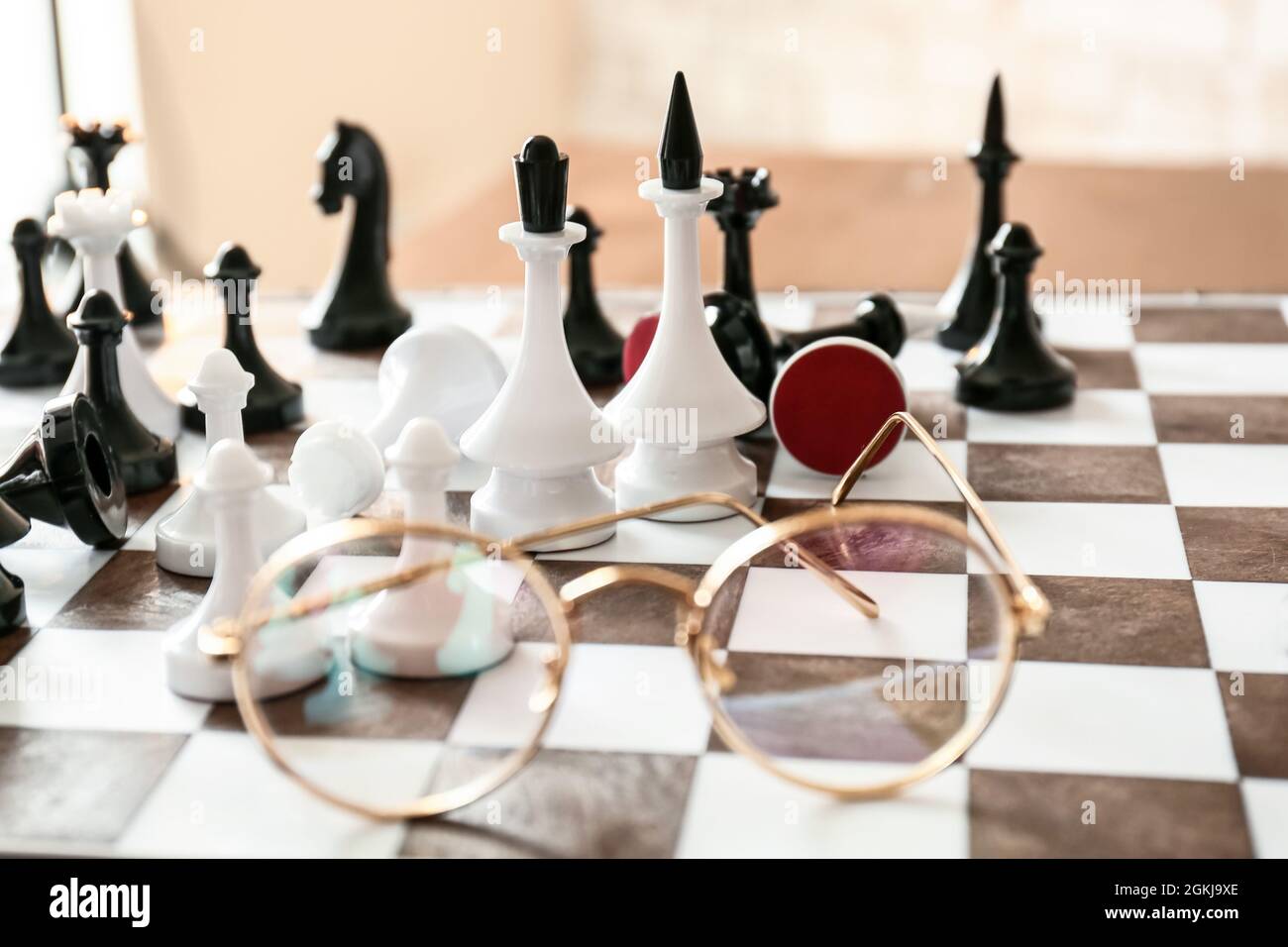 Glasses and chess pieces on game board Stock Photo - Alamy