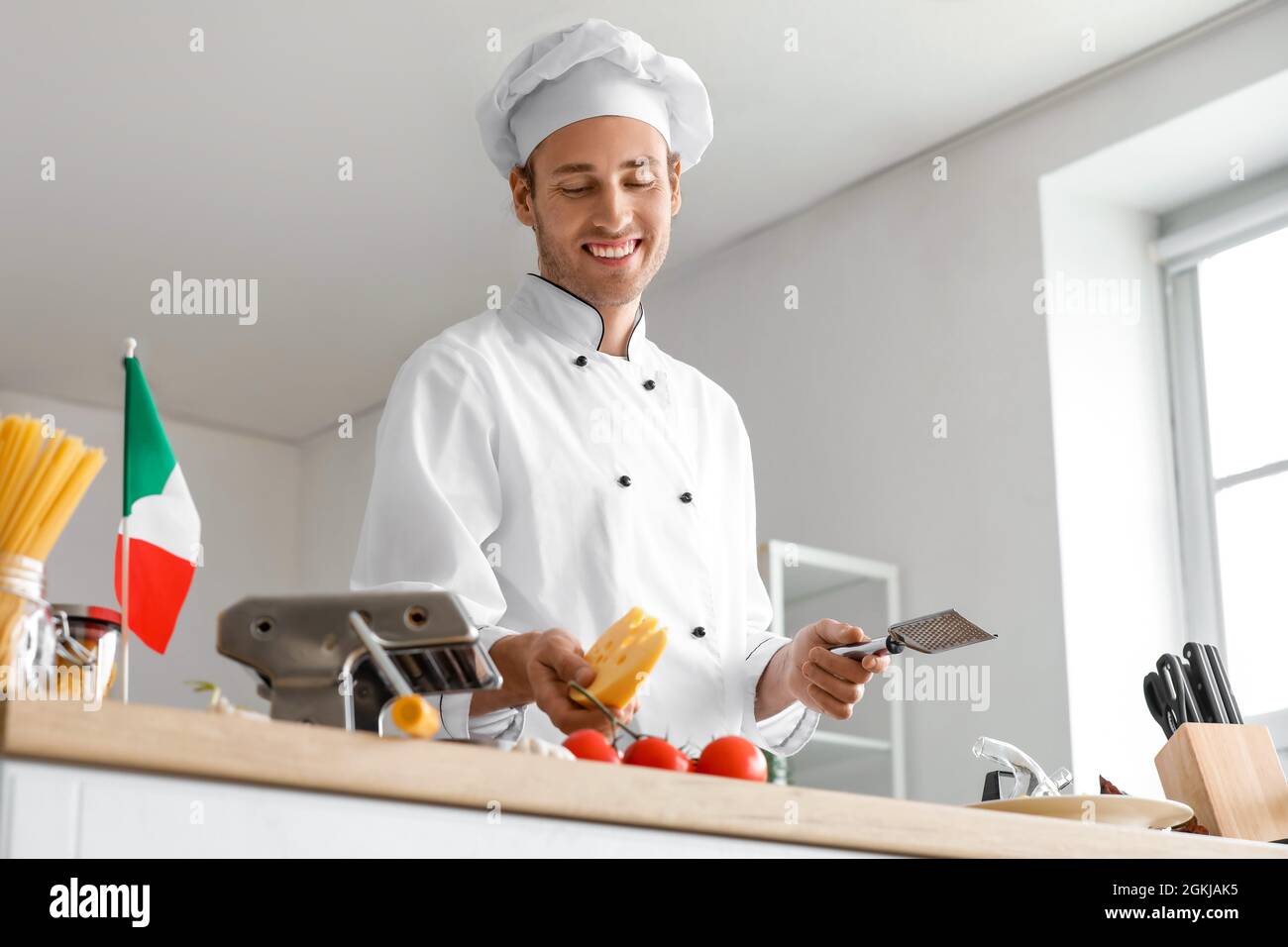 Italian chef with cheese and grater in kitchen Stock Photo - Alamy