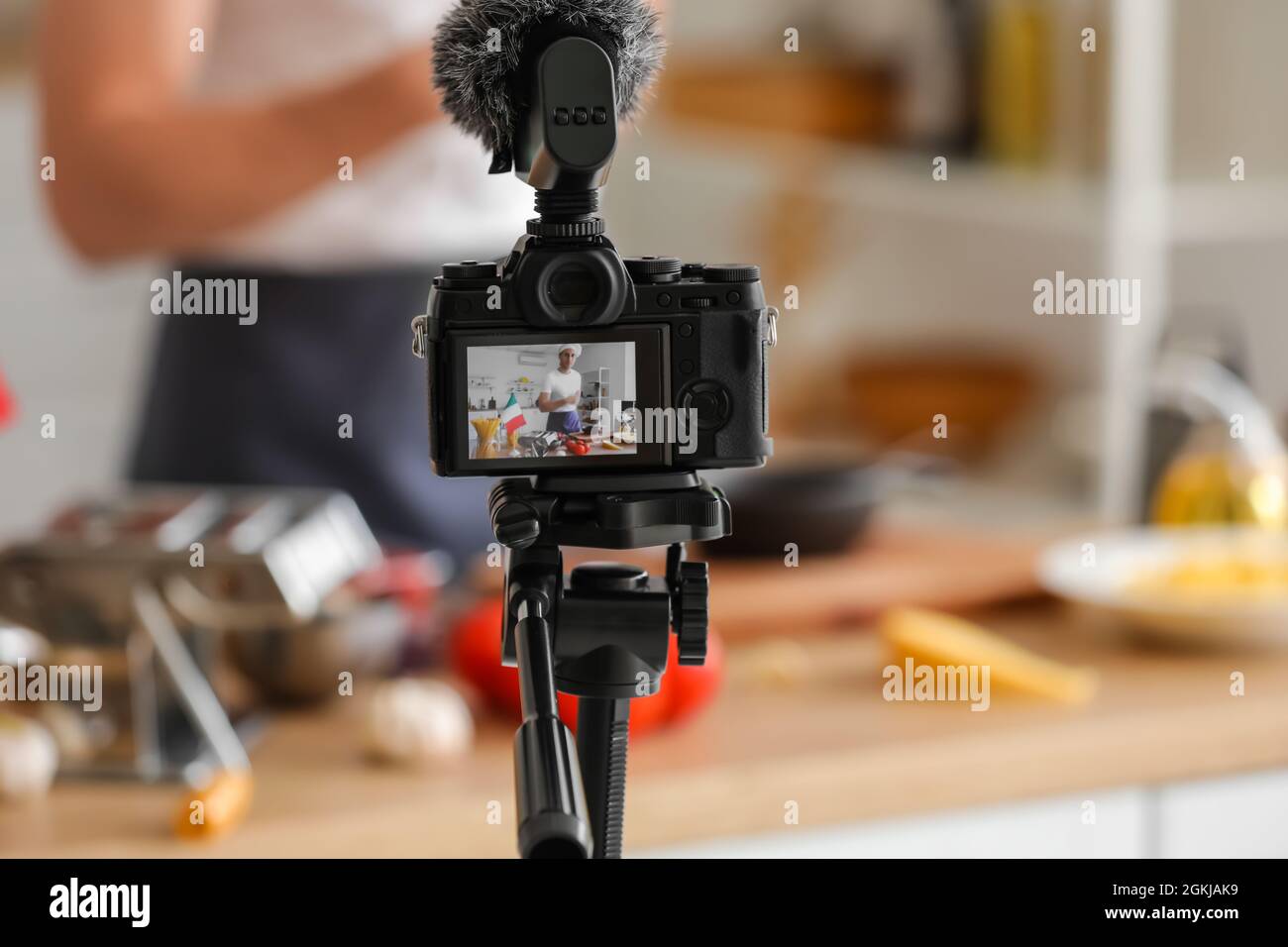 Handsome Italian chef with saucepan on display of photo camera in ...