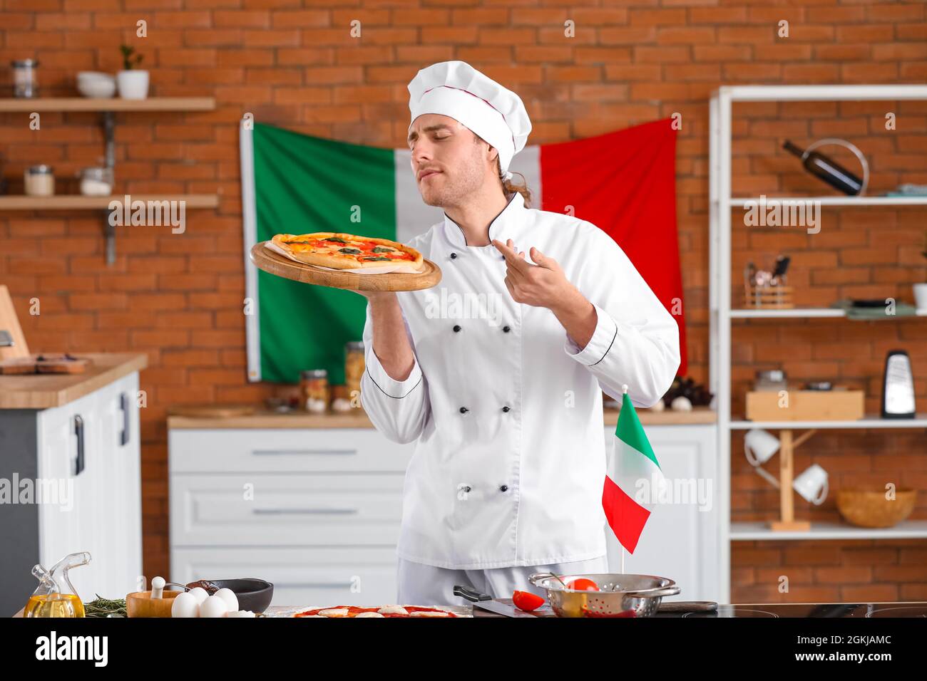 Italian chef with delicious pizza in kitchen Stock Photo - Alamy