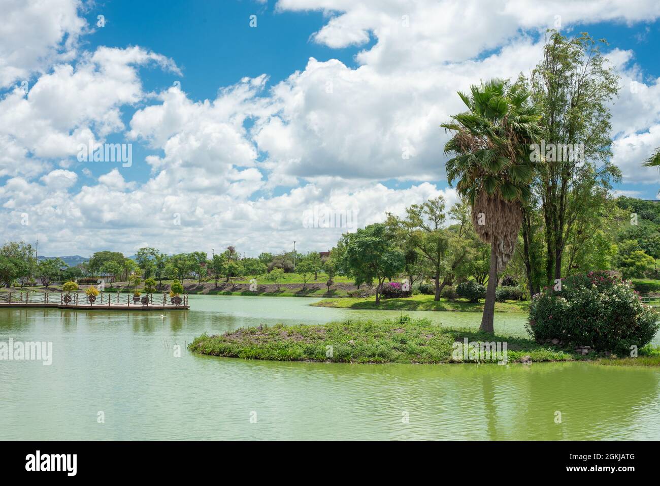 small island inside a lake with green trees in the background and a ...