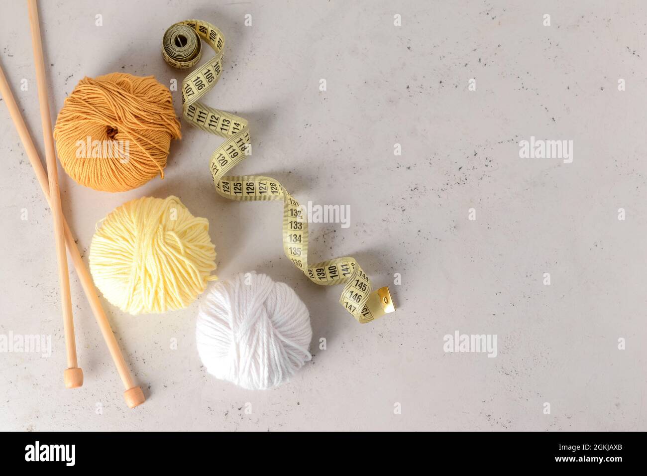 Knitting yarn, needles and measuring tape on light background Stock ...