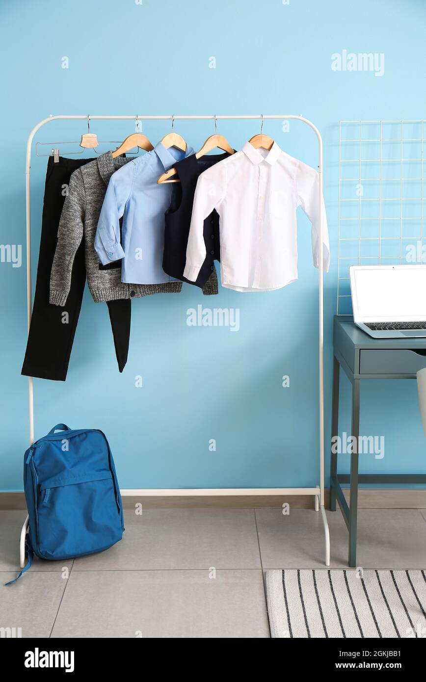 Workplace and rack with school uniform in interior of room Stock Photo ...