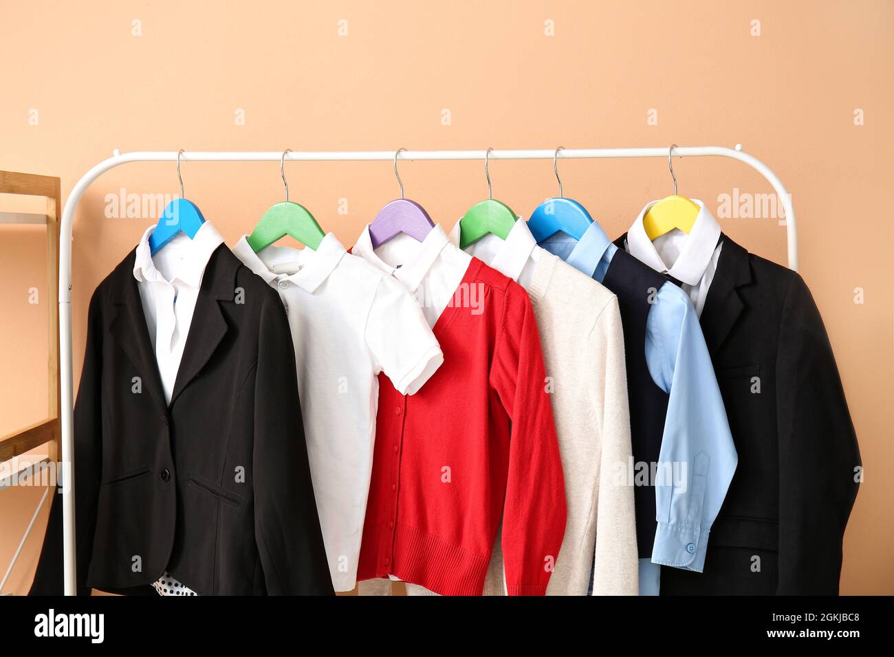 Rack with stylish school uniform near color wall Stock Photo - Alamy