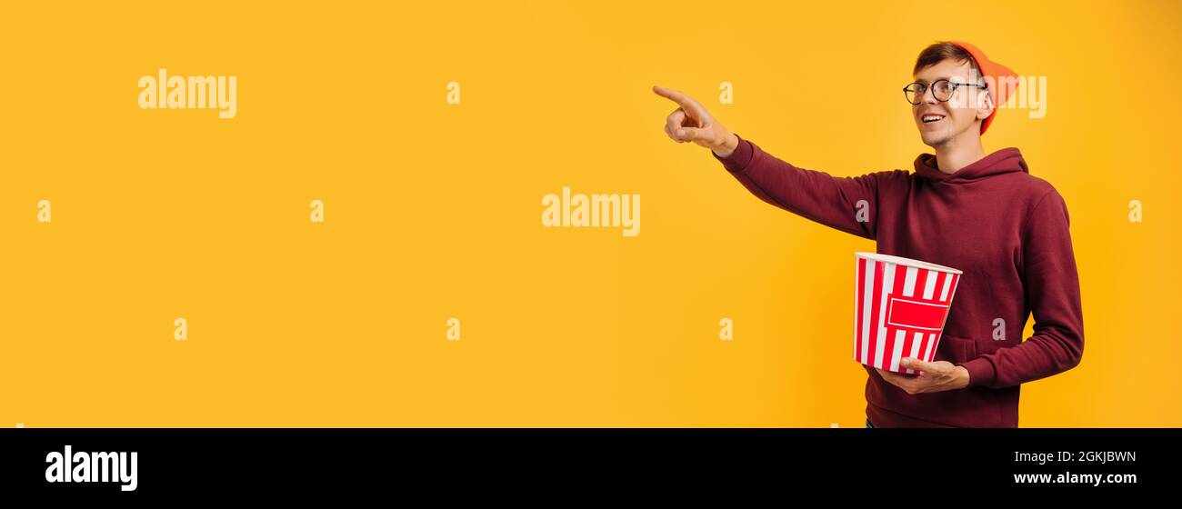 Photo of attractive crazy man holding big bucket of popcorn, eating ...