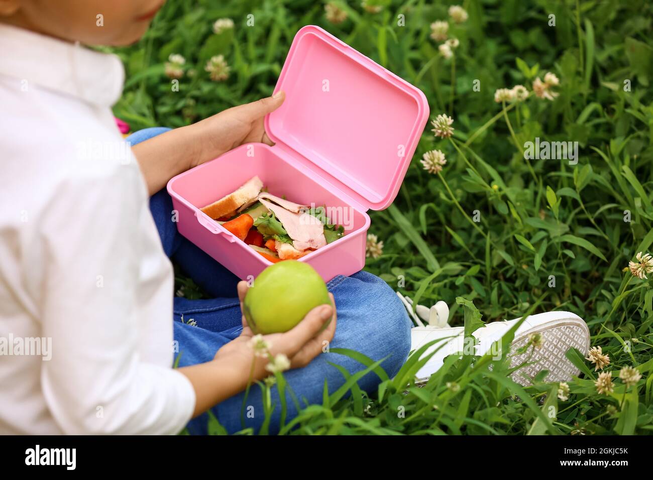 Cute little girl having school lunch outdoors Stock Photo - Alamy