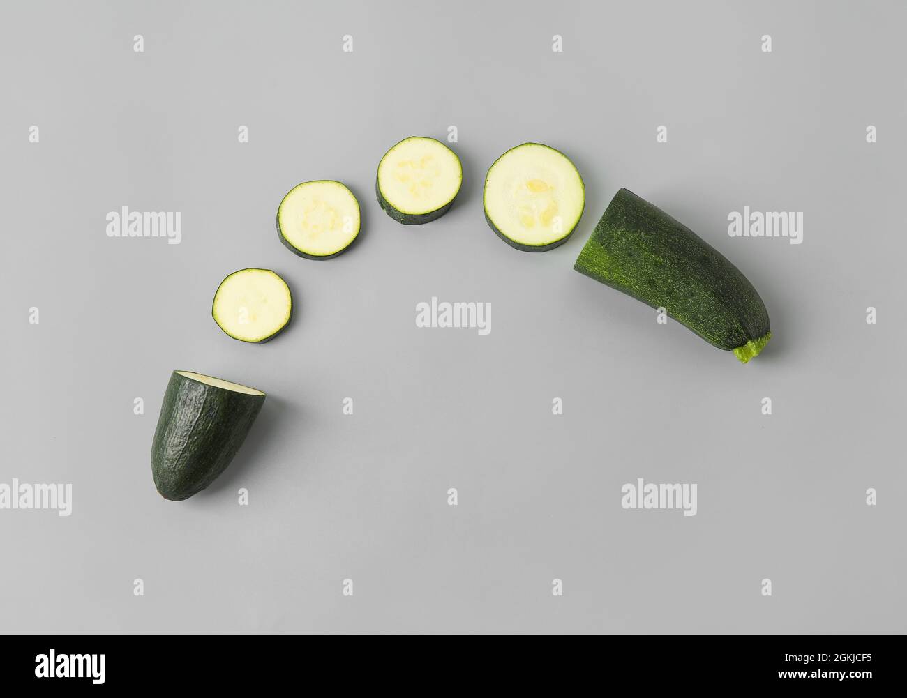 Slices of fresh zucchini squash on grey background Stock Photo - Alamy
