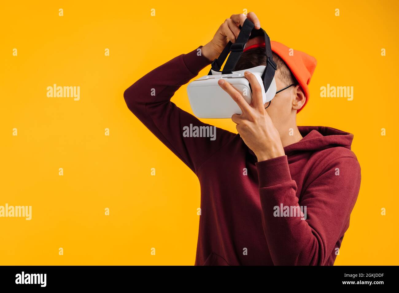 happy man puts on virtual reality glasses, in an orange hat and a red ...