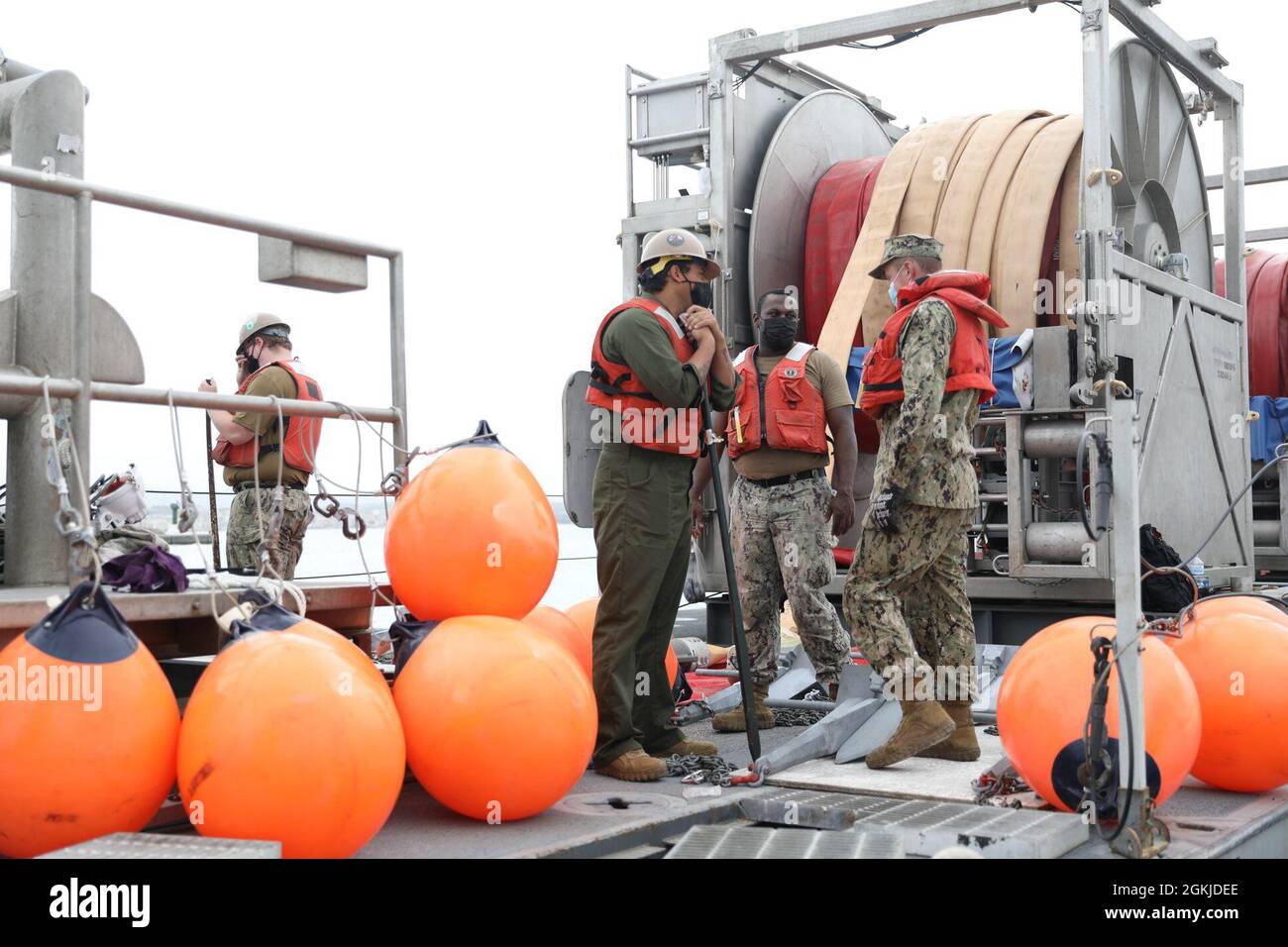 U.S. Navy personnel stand on a floating platform during the theater ...