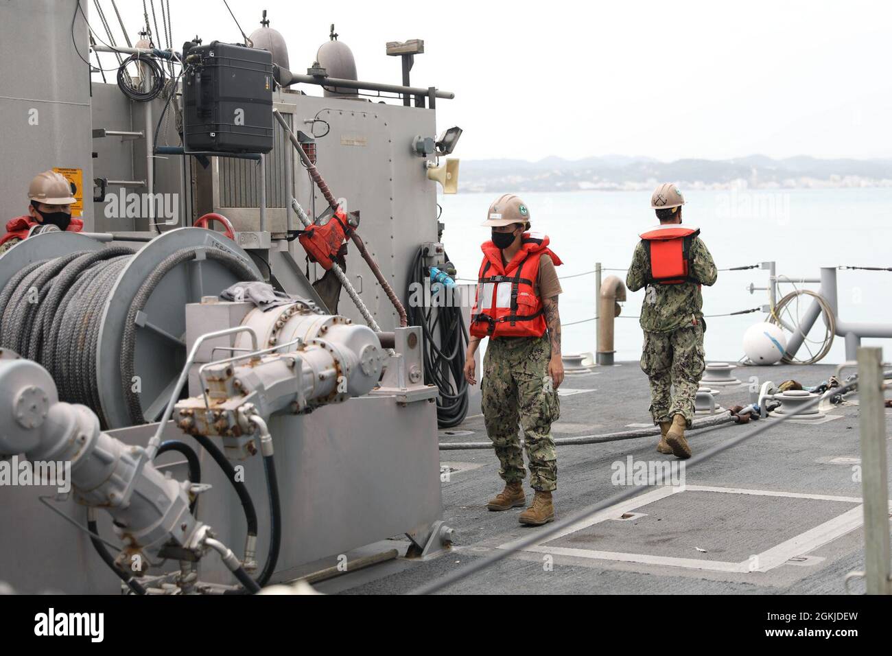 U.S. military personnel stand aboard a vessel as they participate in ...