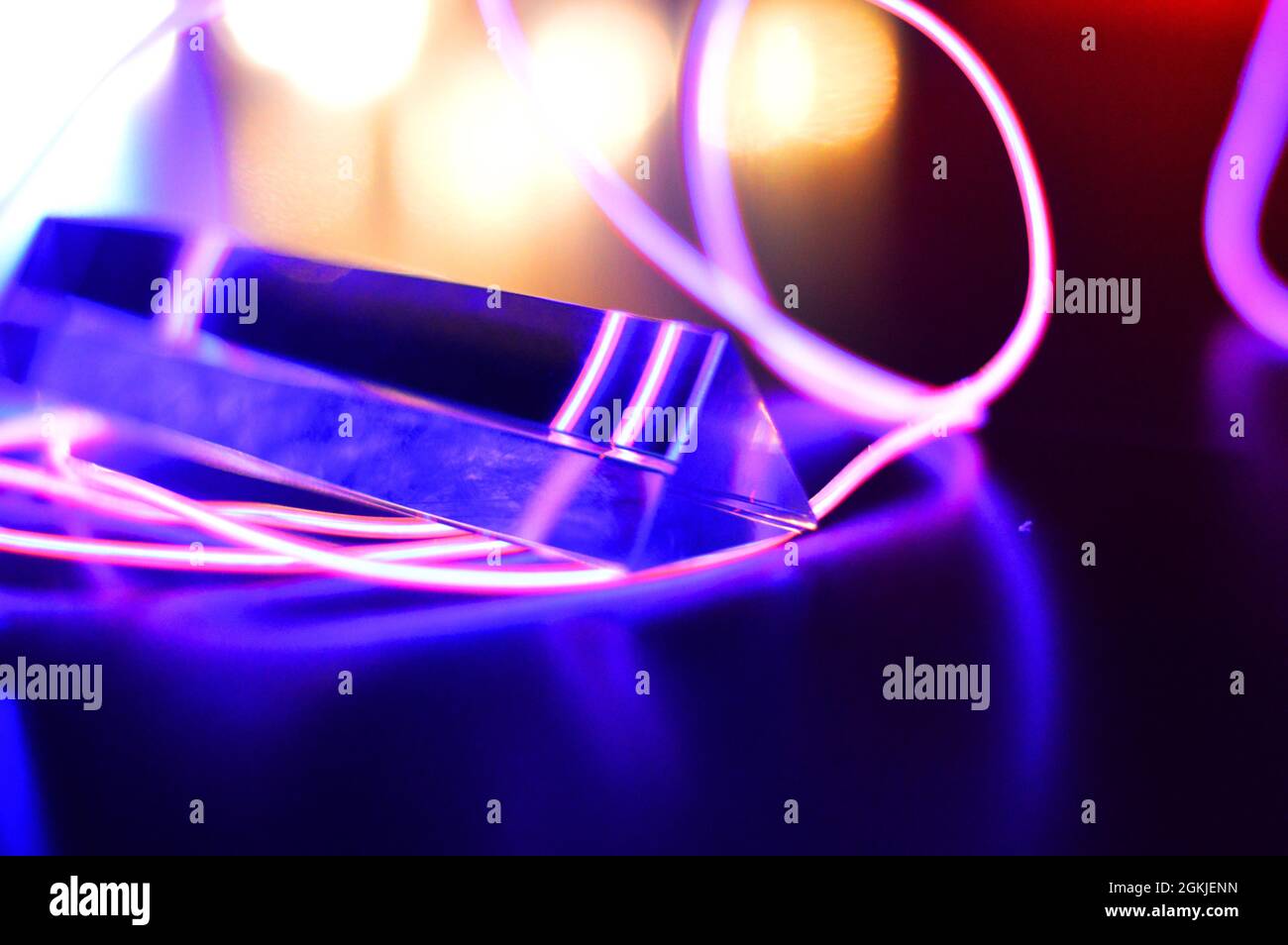 Purple string lights wrapped around a reflective prism Stock Photo - Alamy