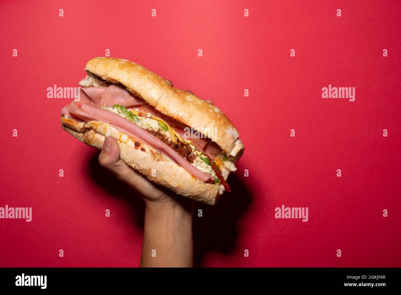 a hand holds a barda cake, mexican cake, mexican food, mexican sandwich ...