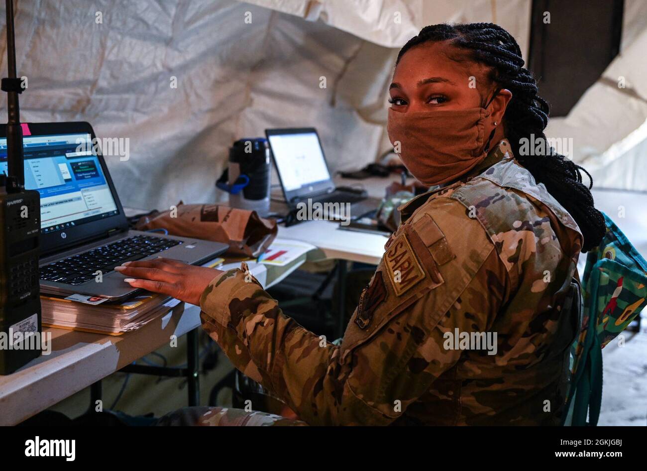 U.S. Air Force Airman logs into a computer to assist with the control ...