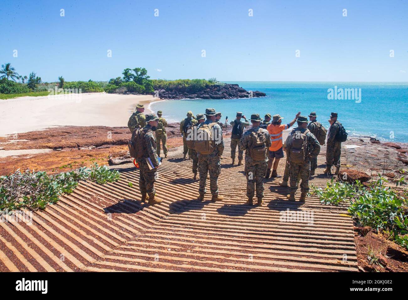 U.S. Marines and Australian Defence Force members stand at a boat ramp ...