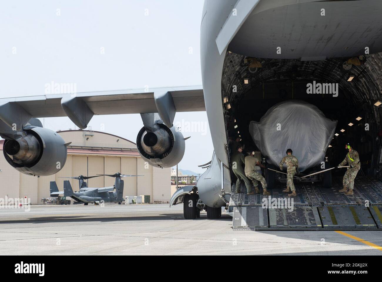 Airmen assigned to the 730th Air Mobility Squadron load a C-17 engine ...