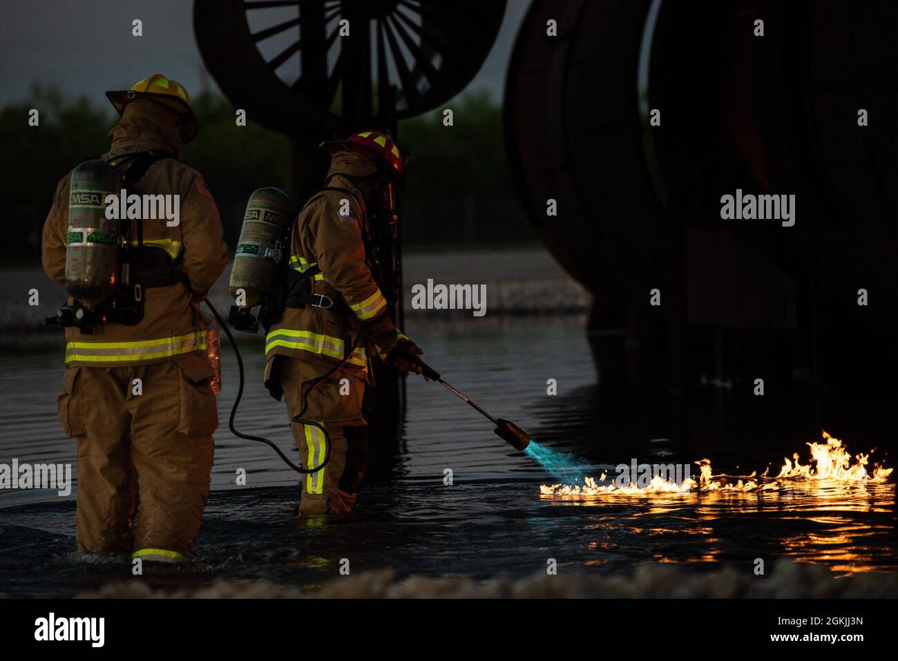 Two firefighters assigned to the 7th Civil Engineer Squadron ignite a ...