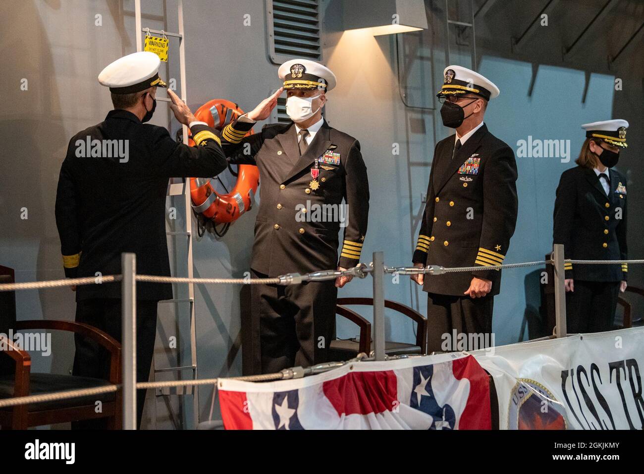 Rear Adm. Jamie Sands (left) returns a salute to Capt. Erik Thors ...